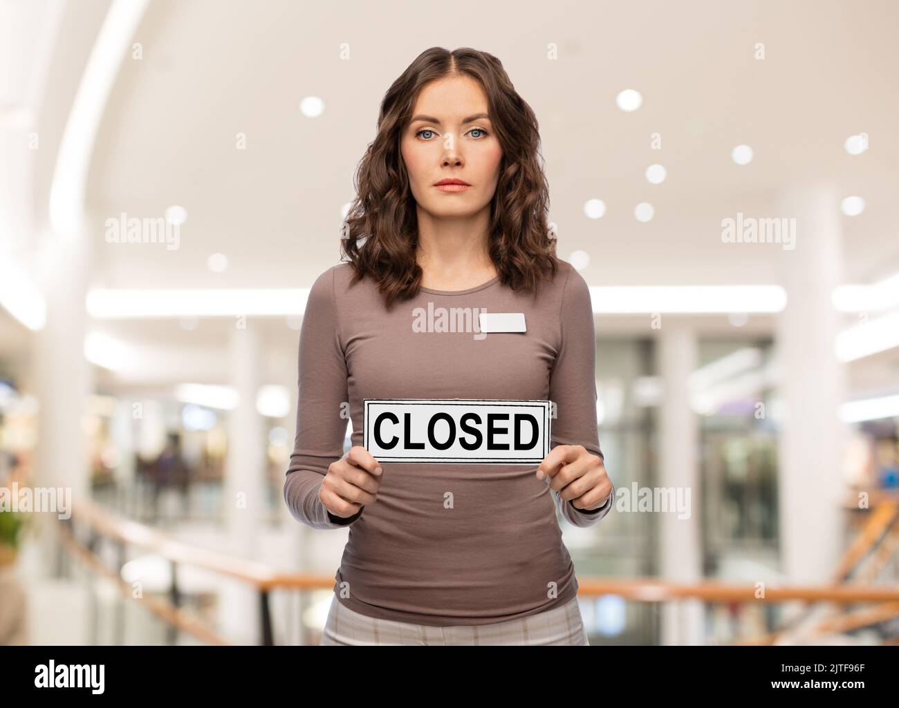 female shop assistant with closed sign at mall Stock Photo - Alamy