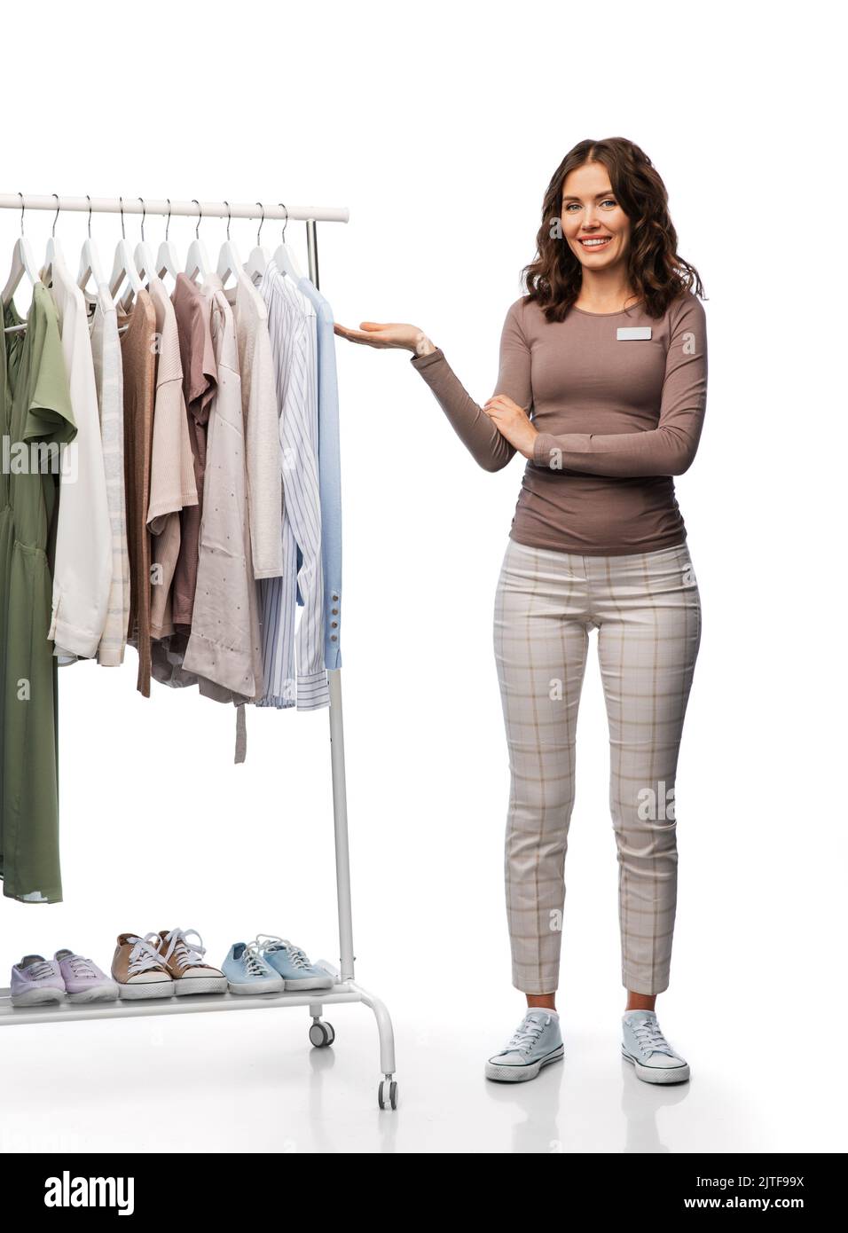 happy female shop assistant with clothes on hanger Stock Photo - Alamy