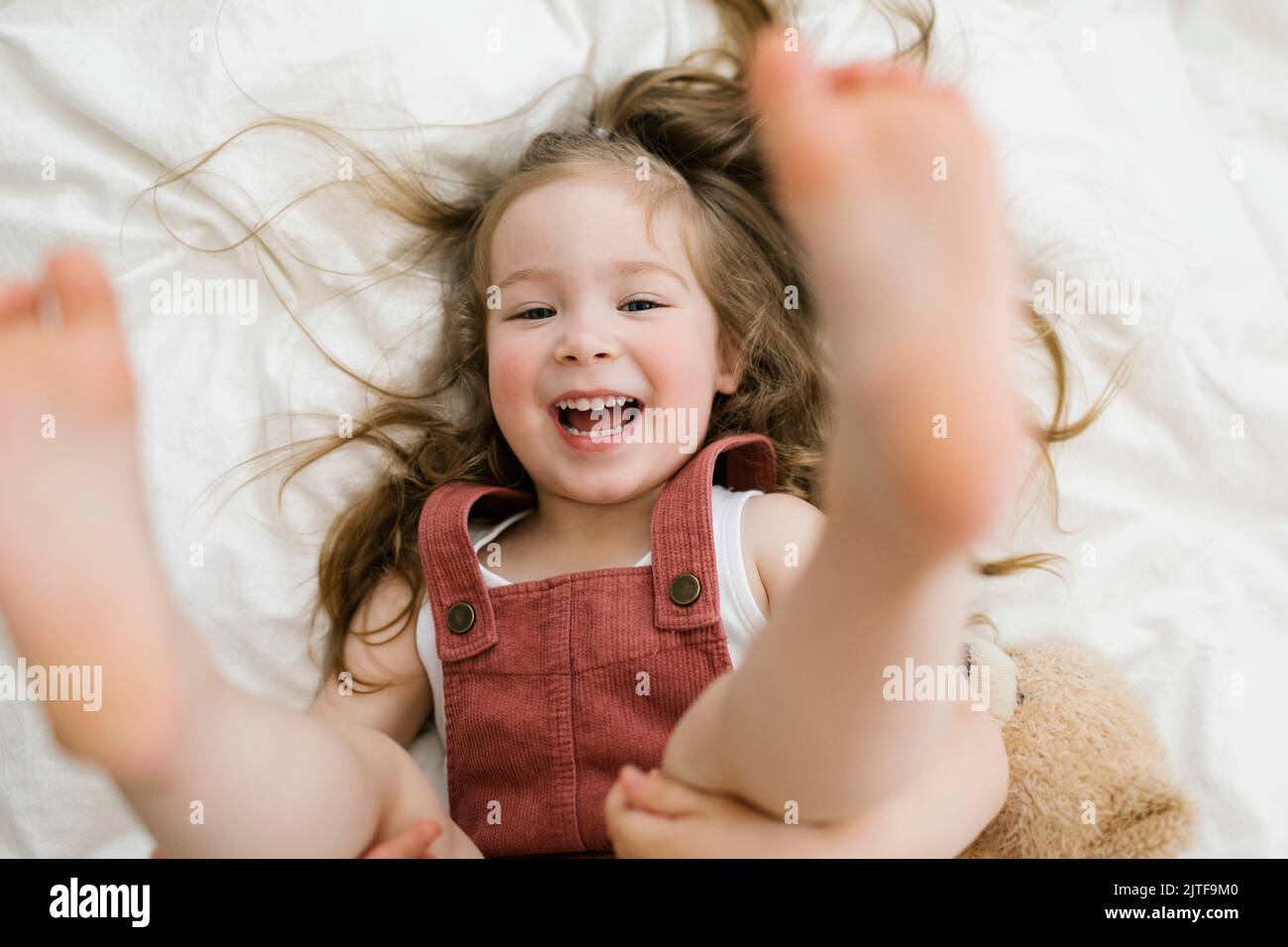 Laughing playful girl (2-3) on bed Stock Photo - Alamy