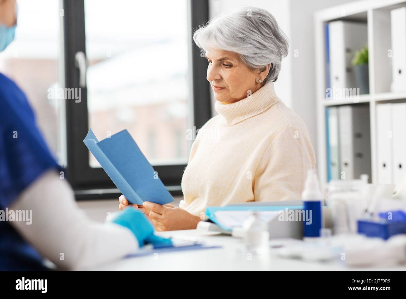 doctor and senior woman reading medical brochure Stock Photo - Alamy