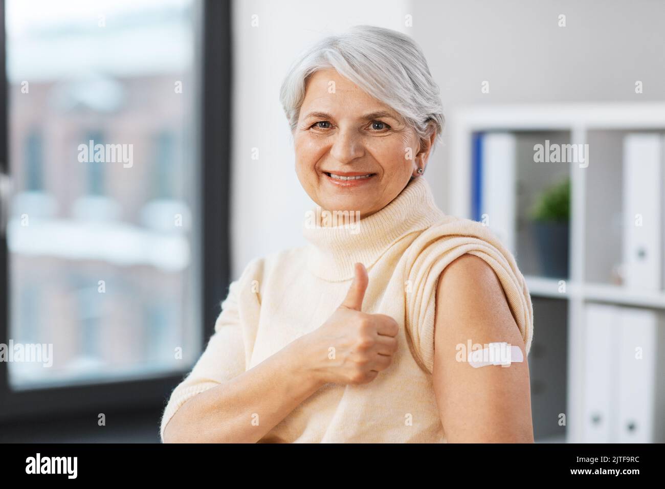 smiling vaccinated woman with medical patch on arm Stock Photo - Alamy