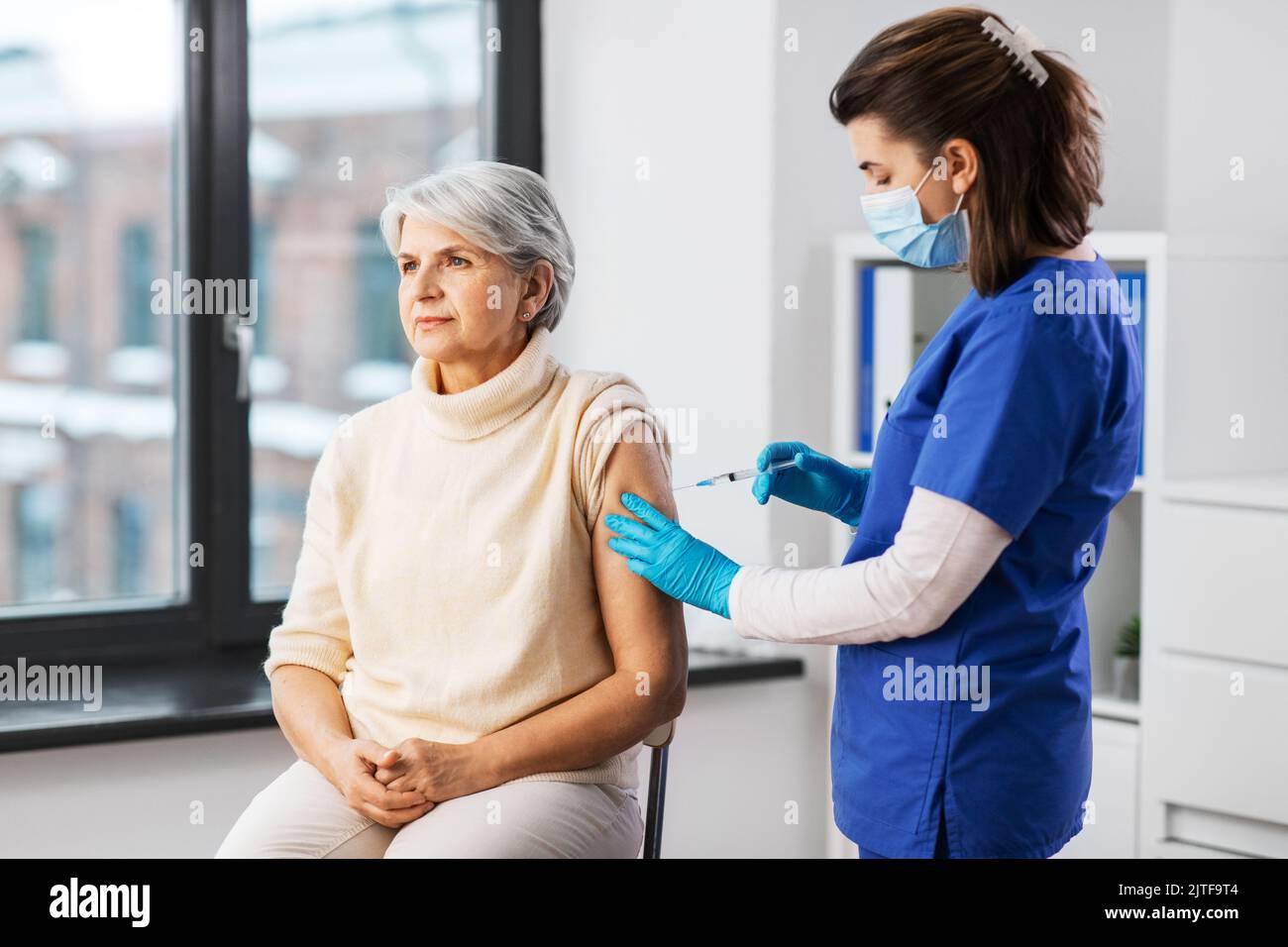 nurse with syringe making injection to woman Stock Photo - Alamy