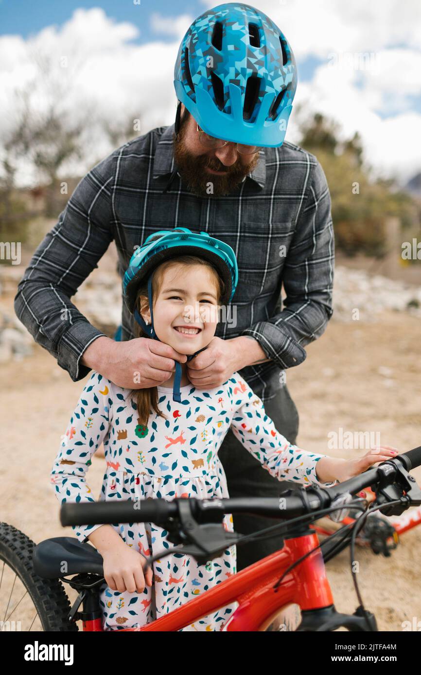 Father adjusting daughters (8-9) bike helmet Stock Photo - Alamy