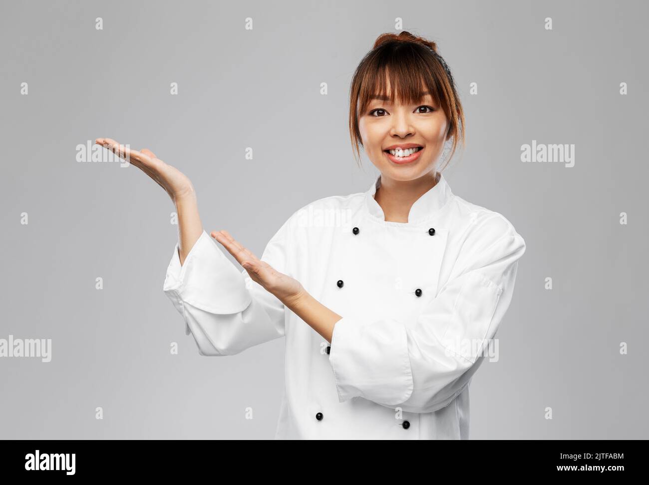 smiling female chef showing something with hands Stock Photo - Alamy