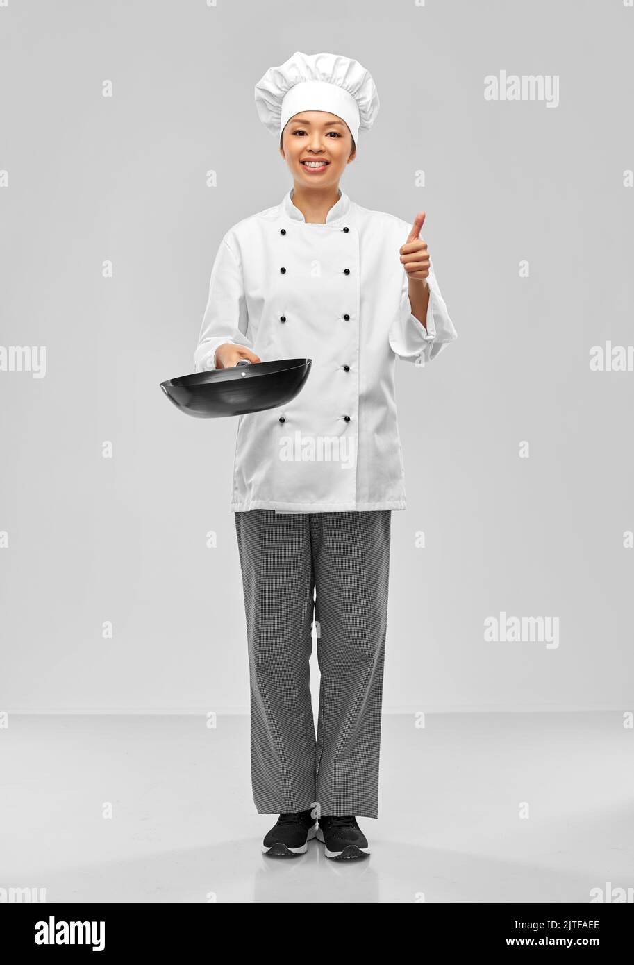 female chef with frying pan showing thumbs up Stock Photo - Alamy