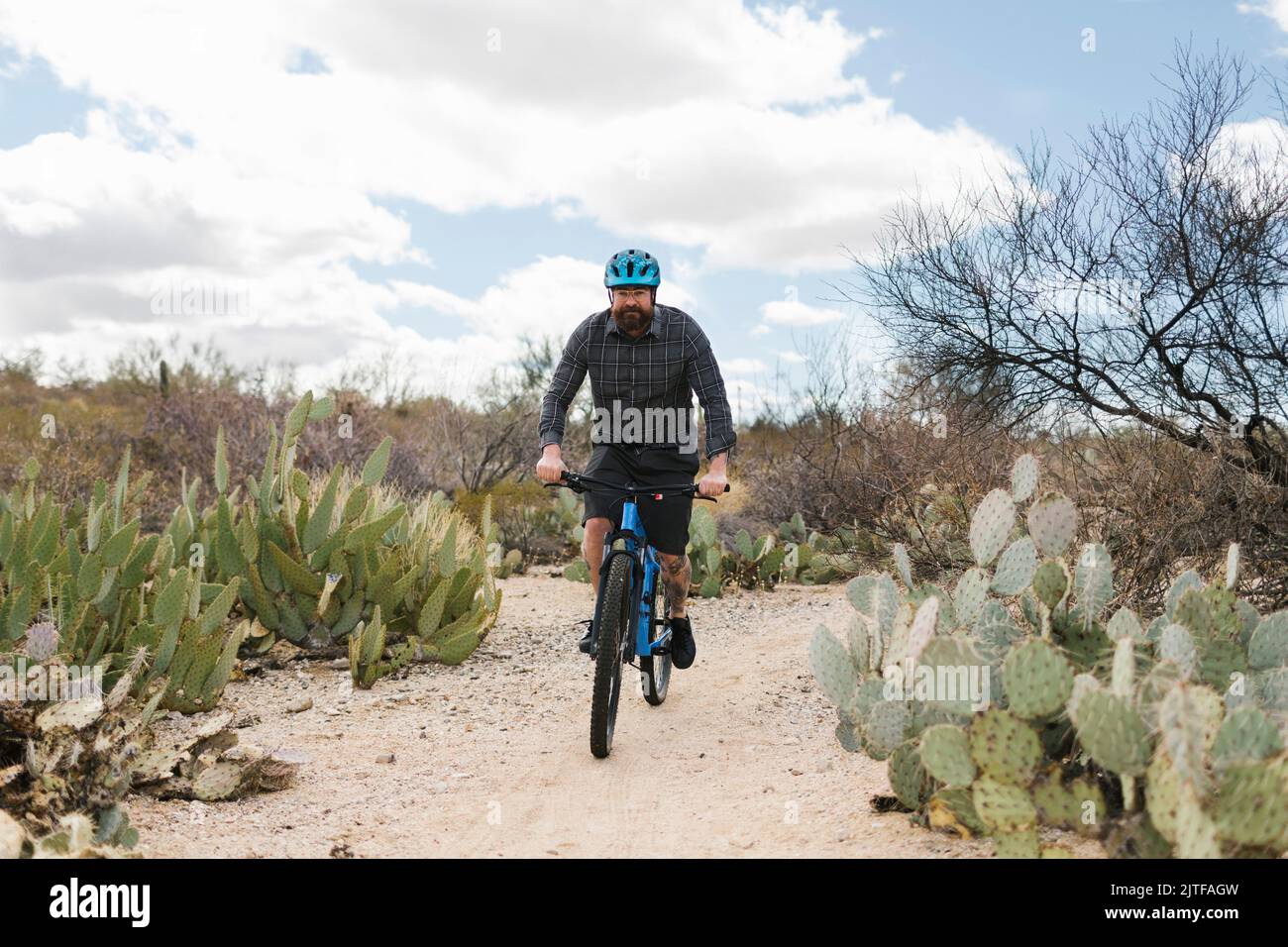 Man riding bike in desert Stock Photo - Alamy