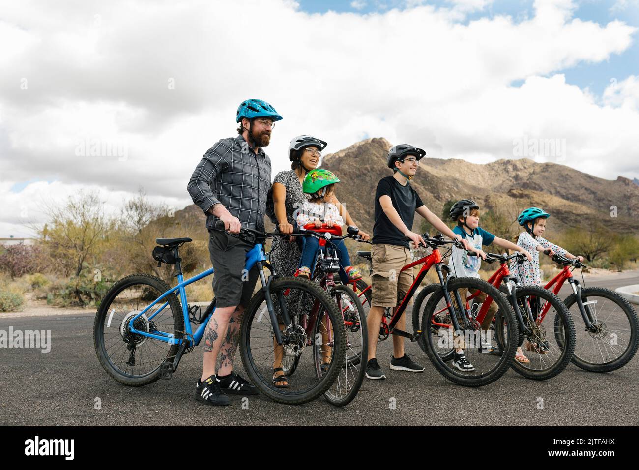 Family with children (2-3, 8-9, 14-15) biking together Stock Photo - Alamy