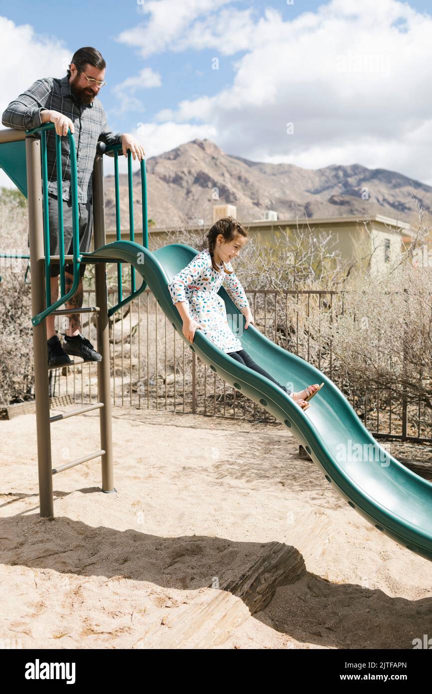 Father and daughter (8-9) on playground slide Stock Photo - Alamy