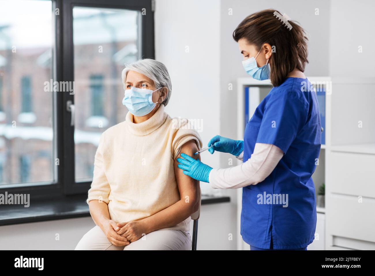 nurse with syringe making injection to woman Stock Photo - Alamy