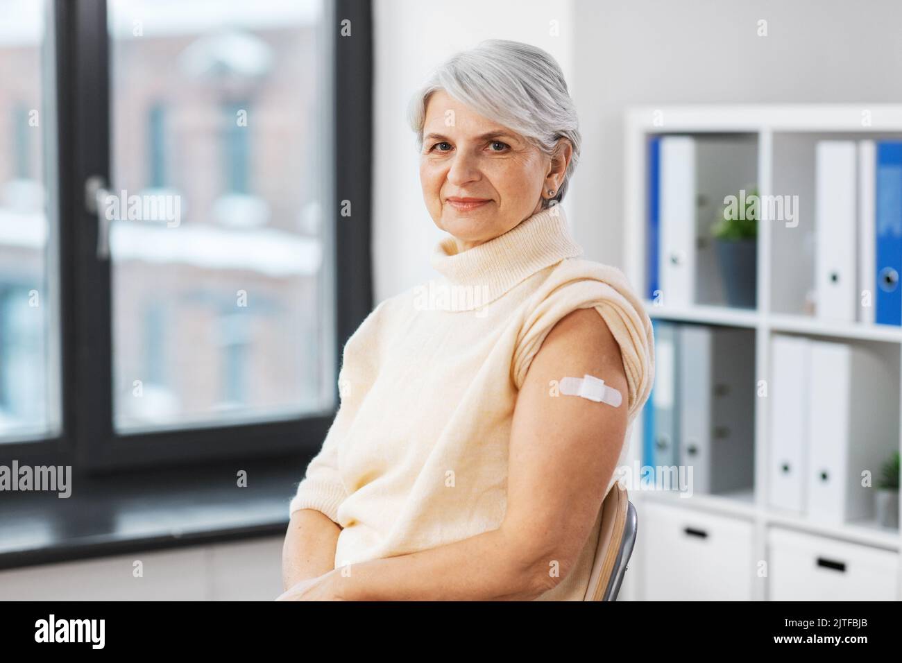 vaccinated woman with medical patch on arm Stock Photo - Alamy