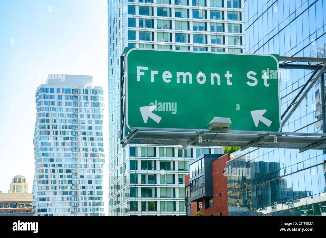 A large, green street sign for Fremont Street hanging from a modern ...