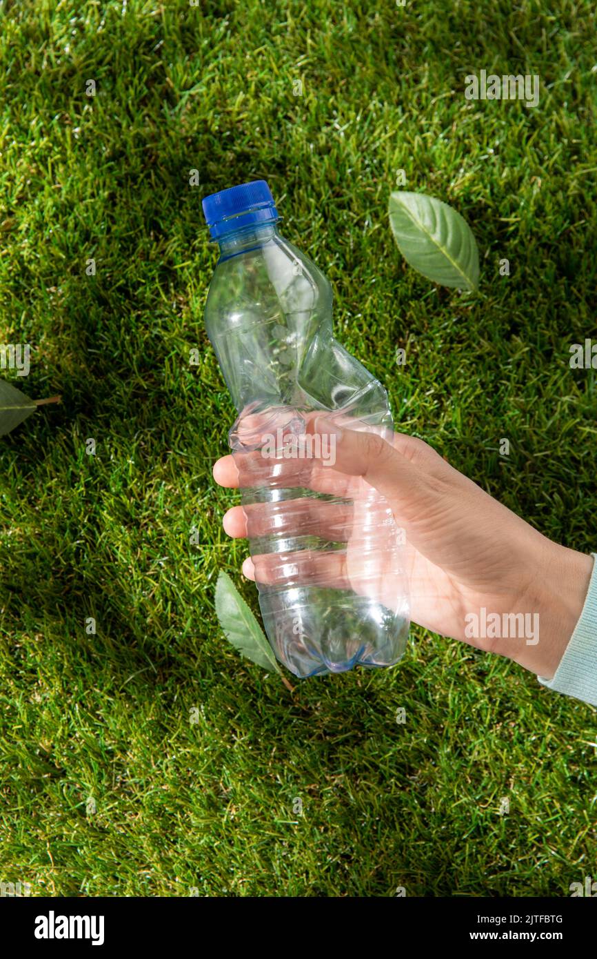 hand removing plastic bottle from grass Stock Photo - Alamy