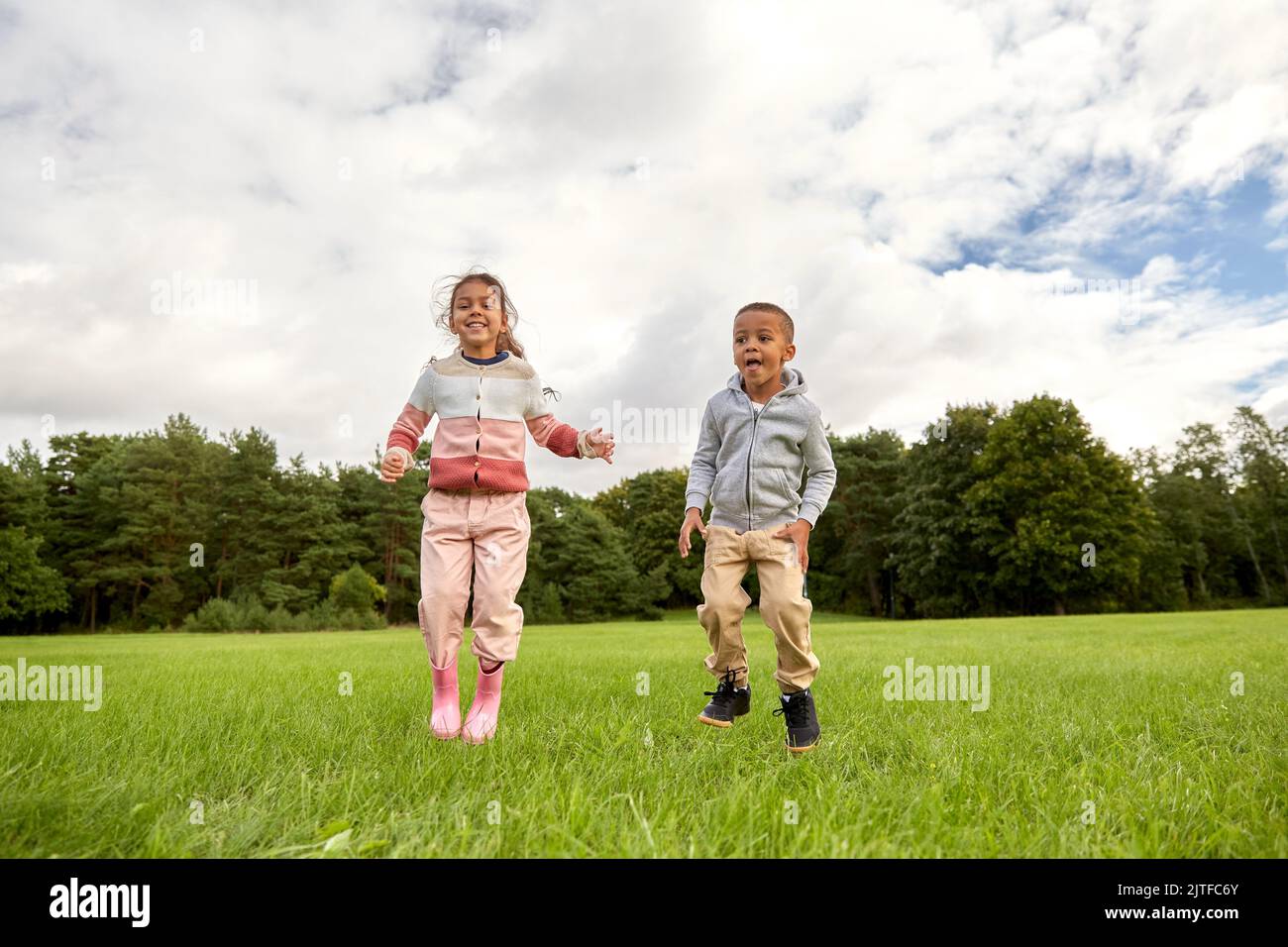 happy children playing and jumping at park Stock Photo - Alamy