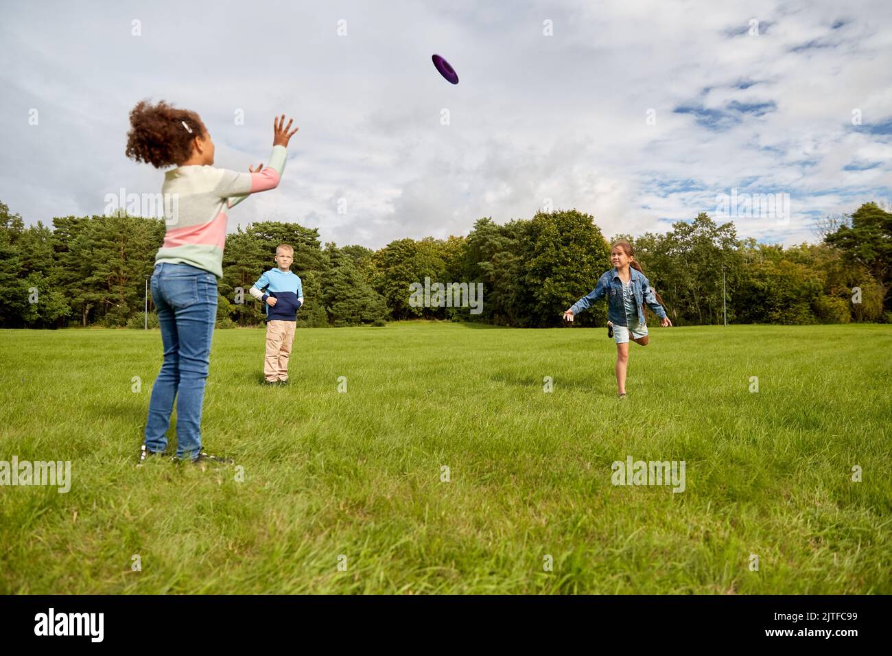 happy children playing with flying disc at park Stock Photo - Alamy