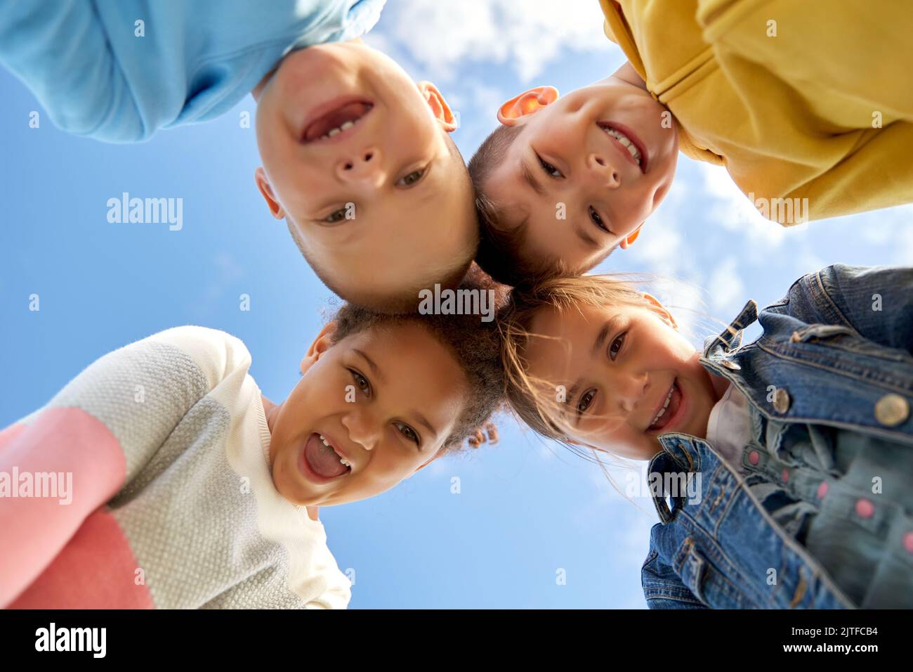 multiethnic group of happy children under blue sky Stock Photo - Alamy