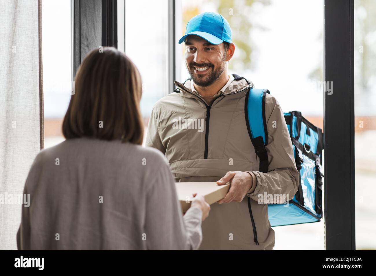food delivery man giving order to female customer Stock Photo - Alamy