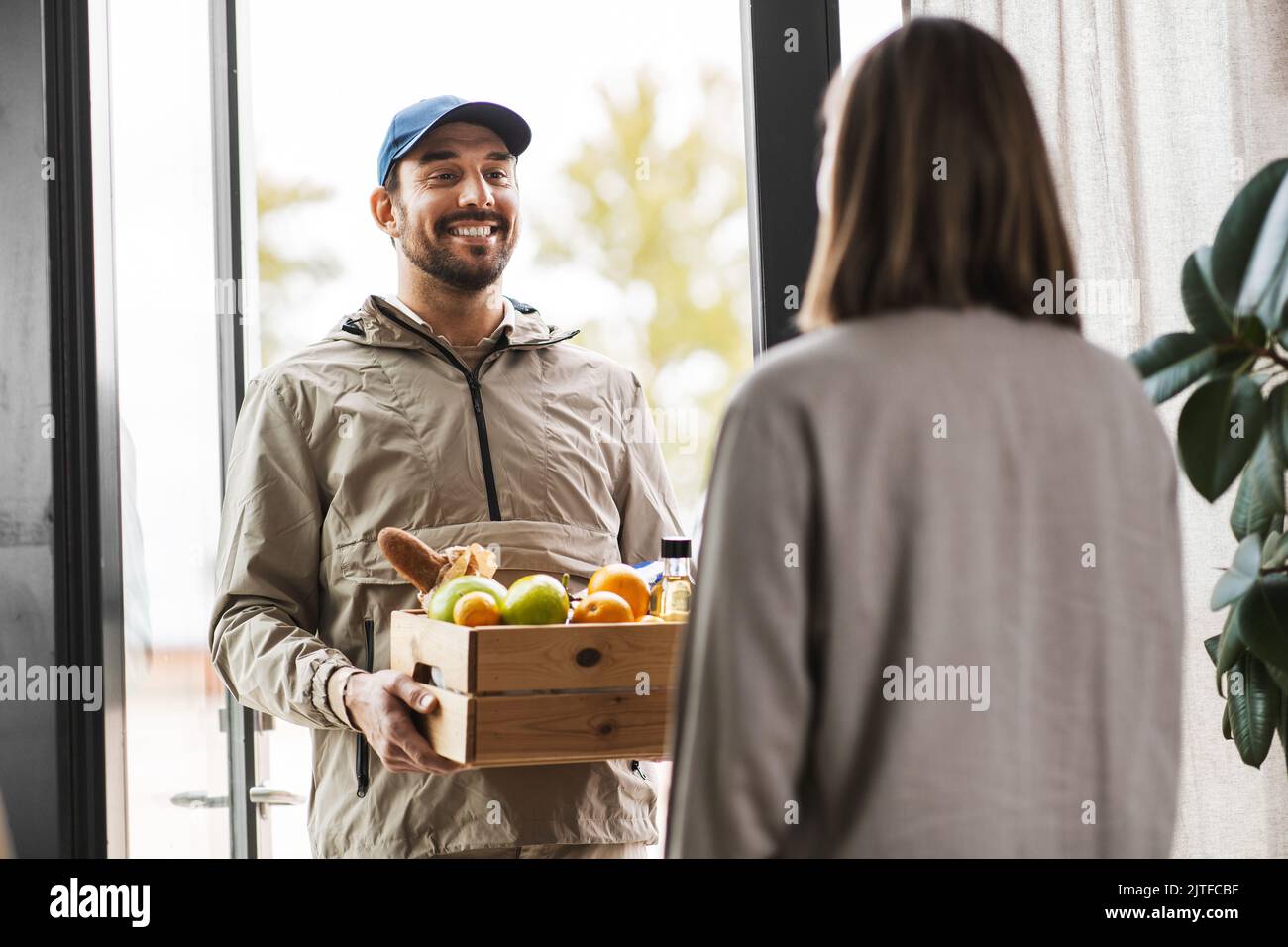 food delivery man giving order to female customer Stock Photo - Alamy