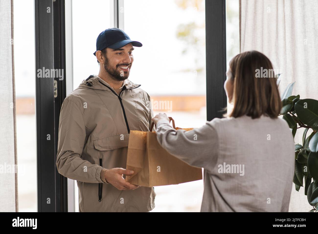 food delivery man giving order to female customer Stock Photo - Alamy