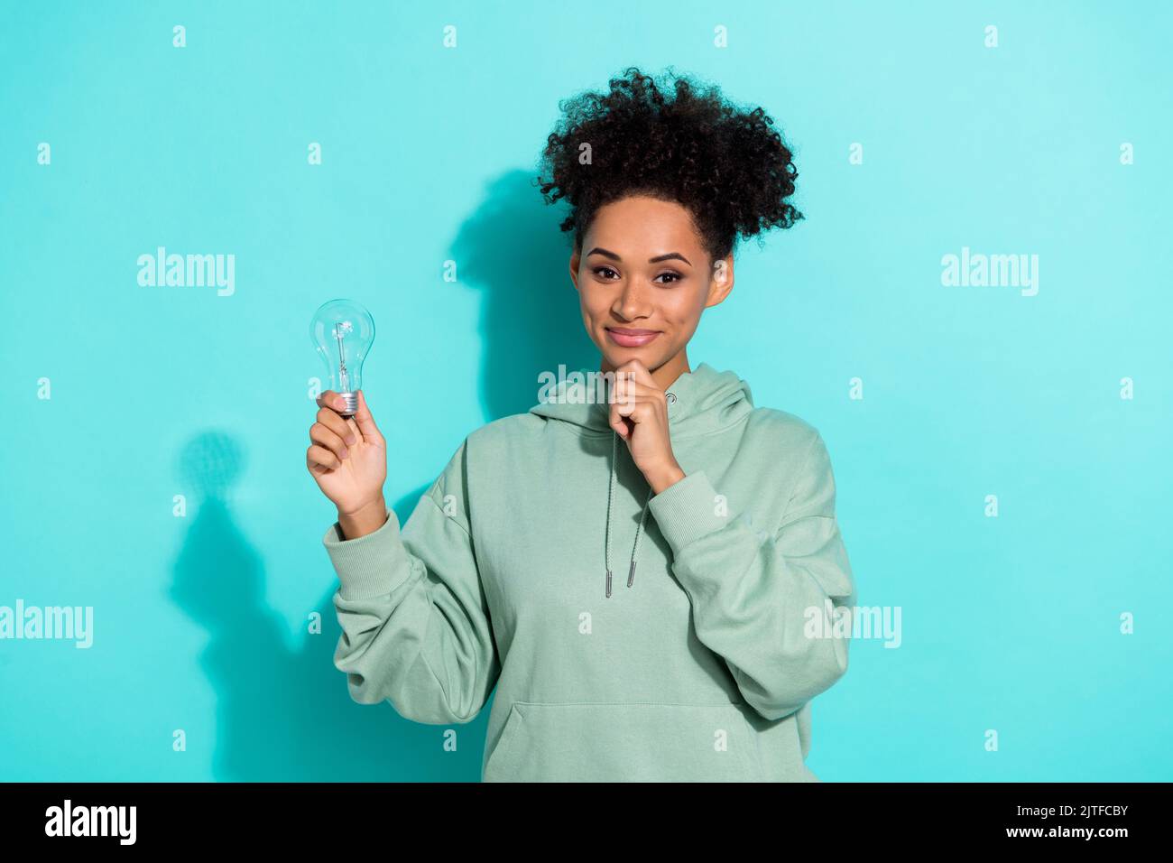 Photo of minded clever person arm hold light bulb touch chin isolated ...