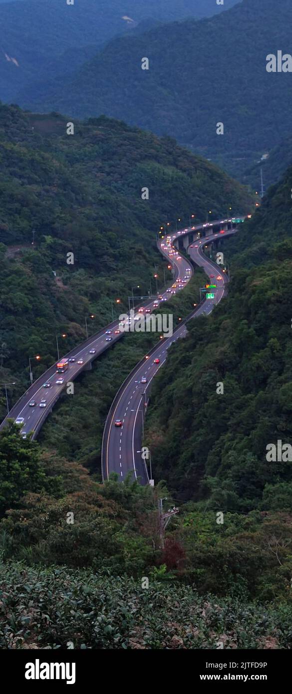 The curved highway through the green rice fields with houses scattered ...