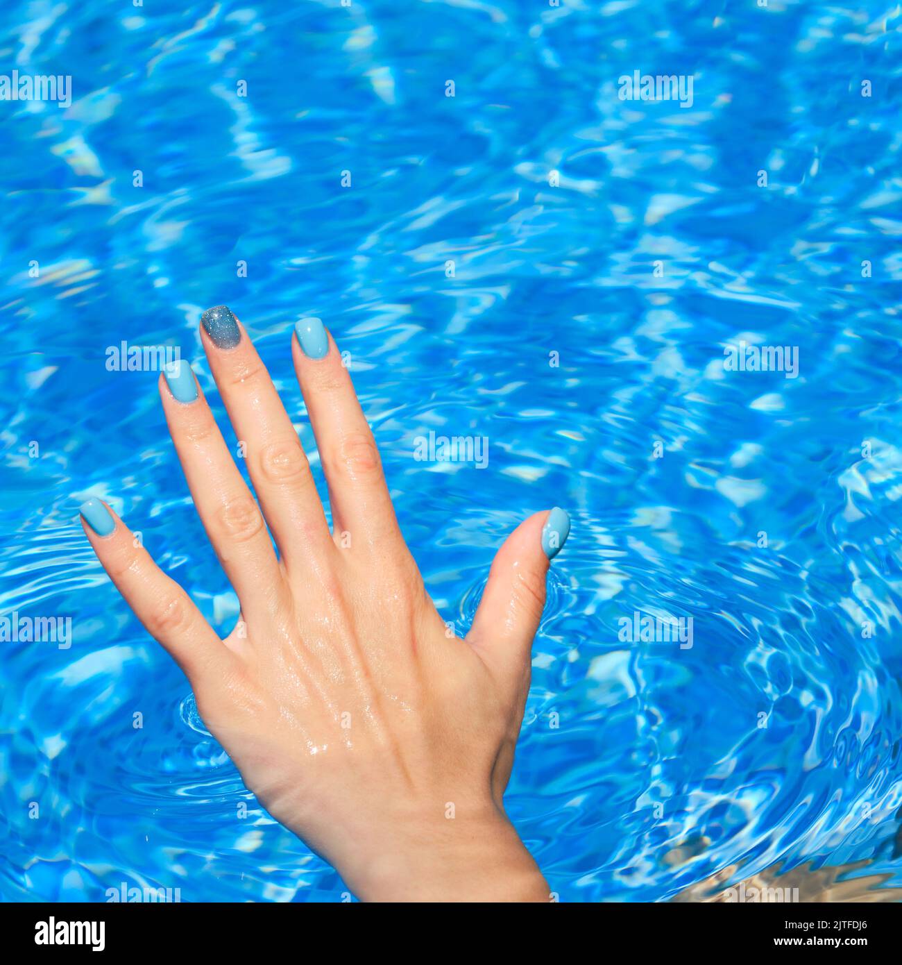 Hand with bright nail polish inside of water Stock Photo - Alamy