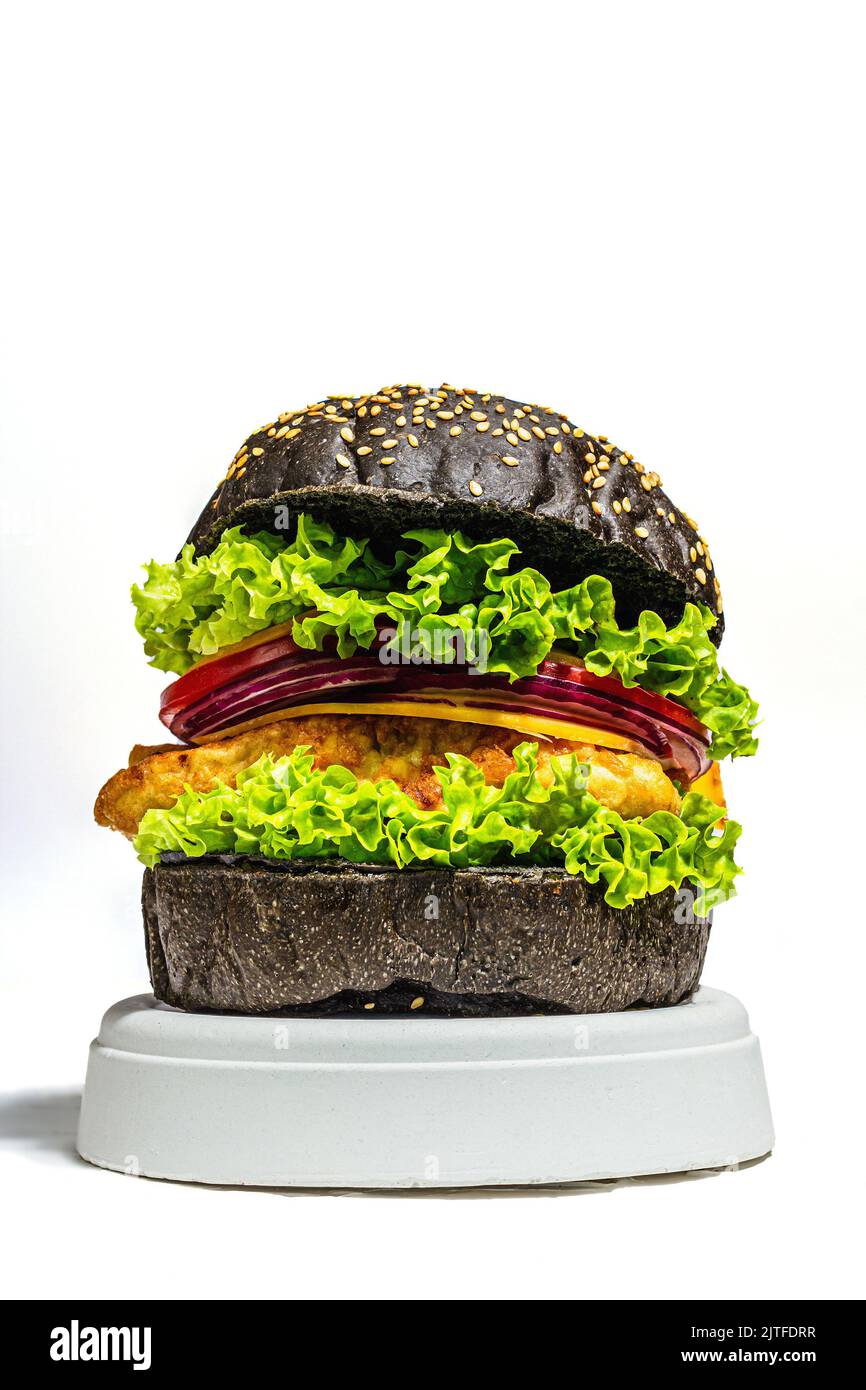 Homemade fish burger with a black bun. Fresh ingredients, ripe ...