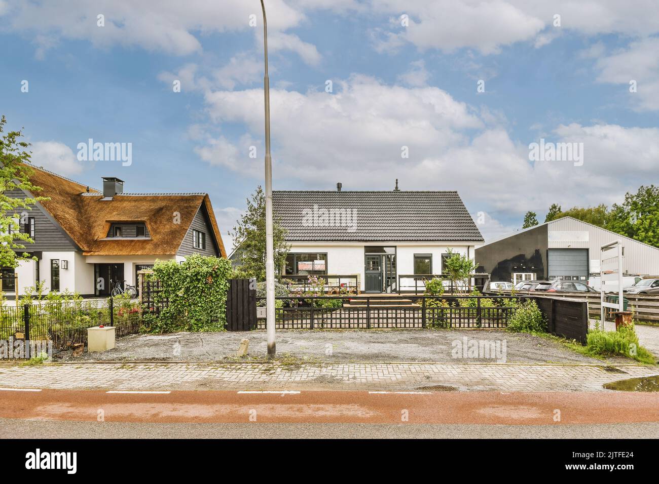 The front view of a brick building with signs,pavement and wooden doors ...