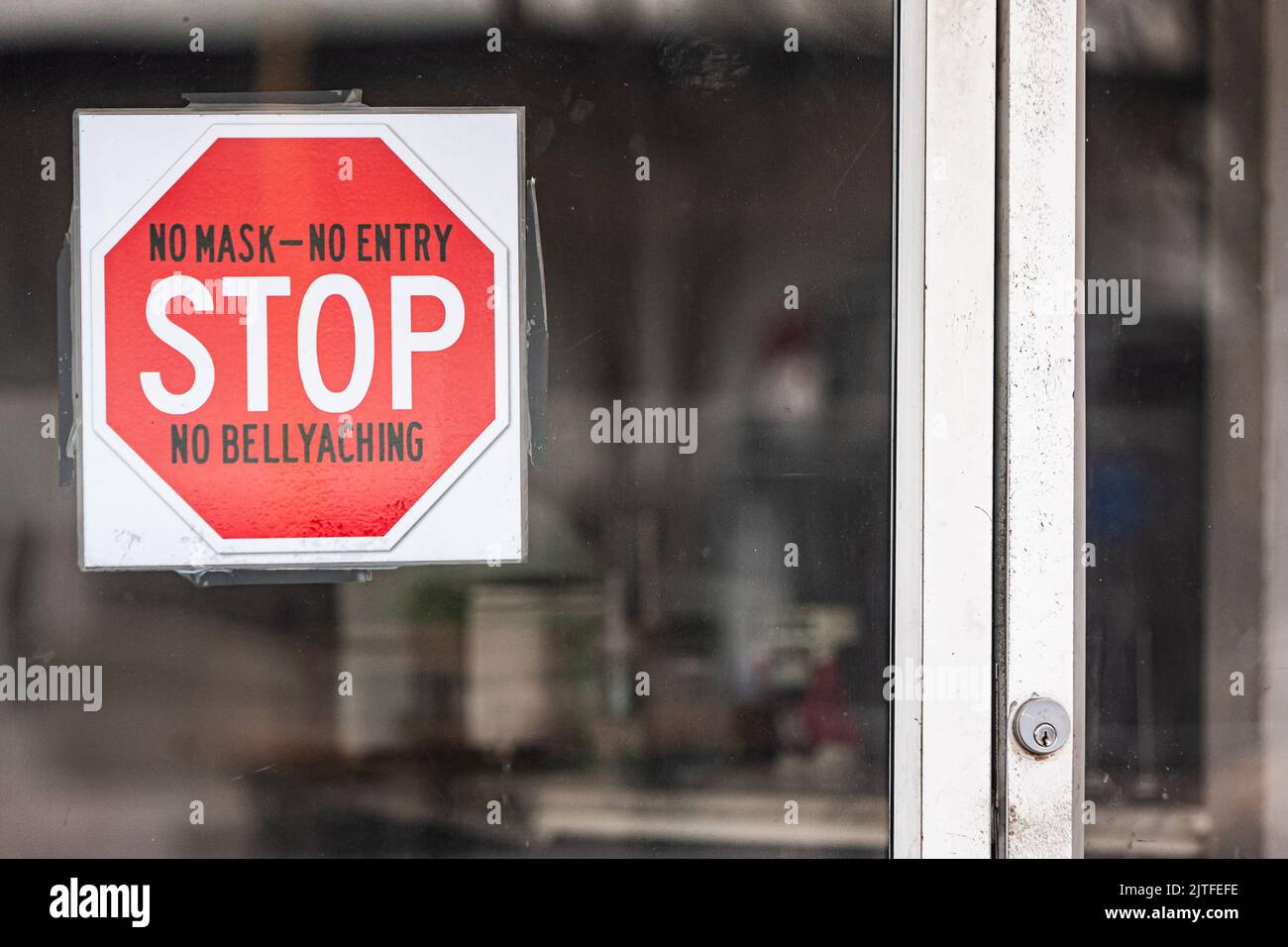 A red stop sign on door of local business says "No mask, no entry, no ...