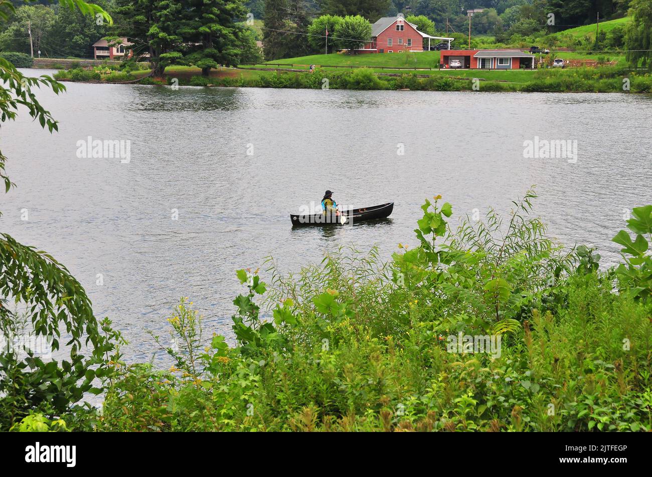 A canoer paddles the tranquil Lake Junaluska in North Carolina's ...