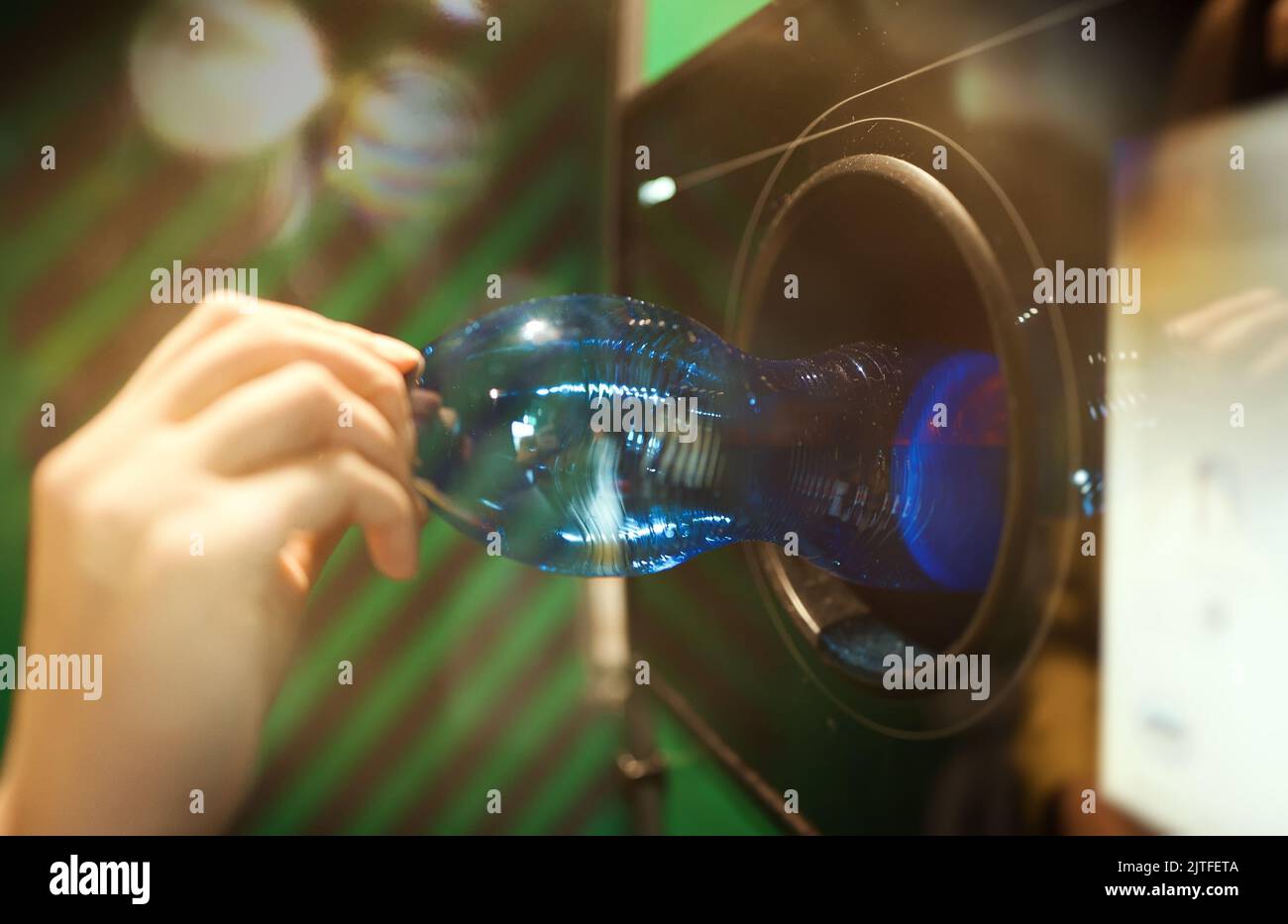 Woman puts bottle in automatic bottle recycling machine. Reverse ...