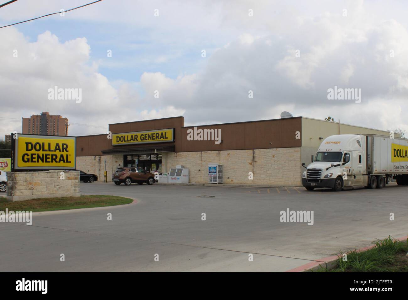 The front view of a Dollar General with a semi truck on the side of the ...
