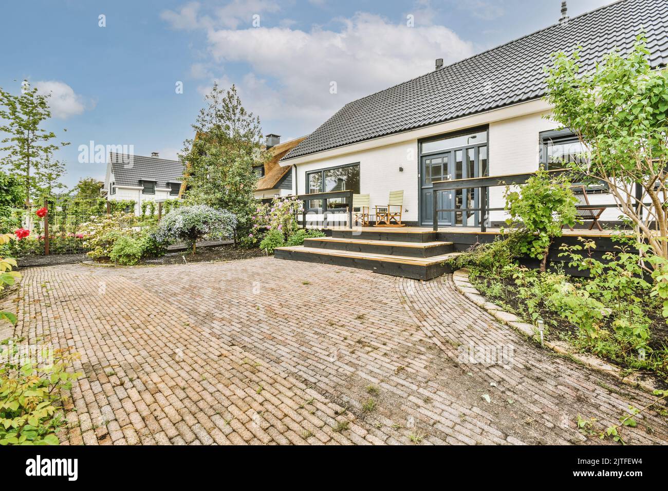 The front view of a brick building with signs,pavement and wooden doors ...