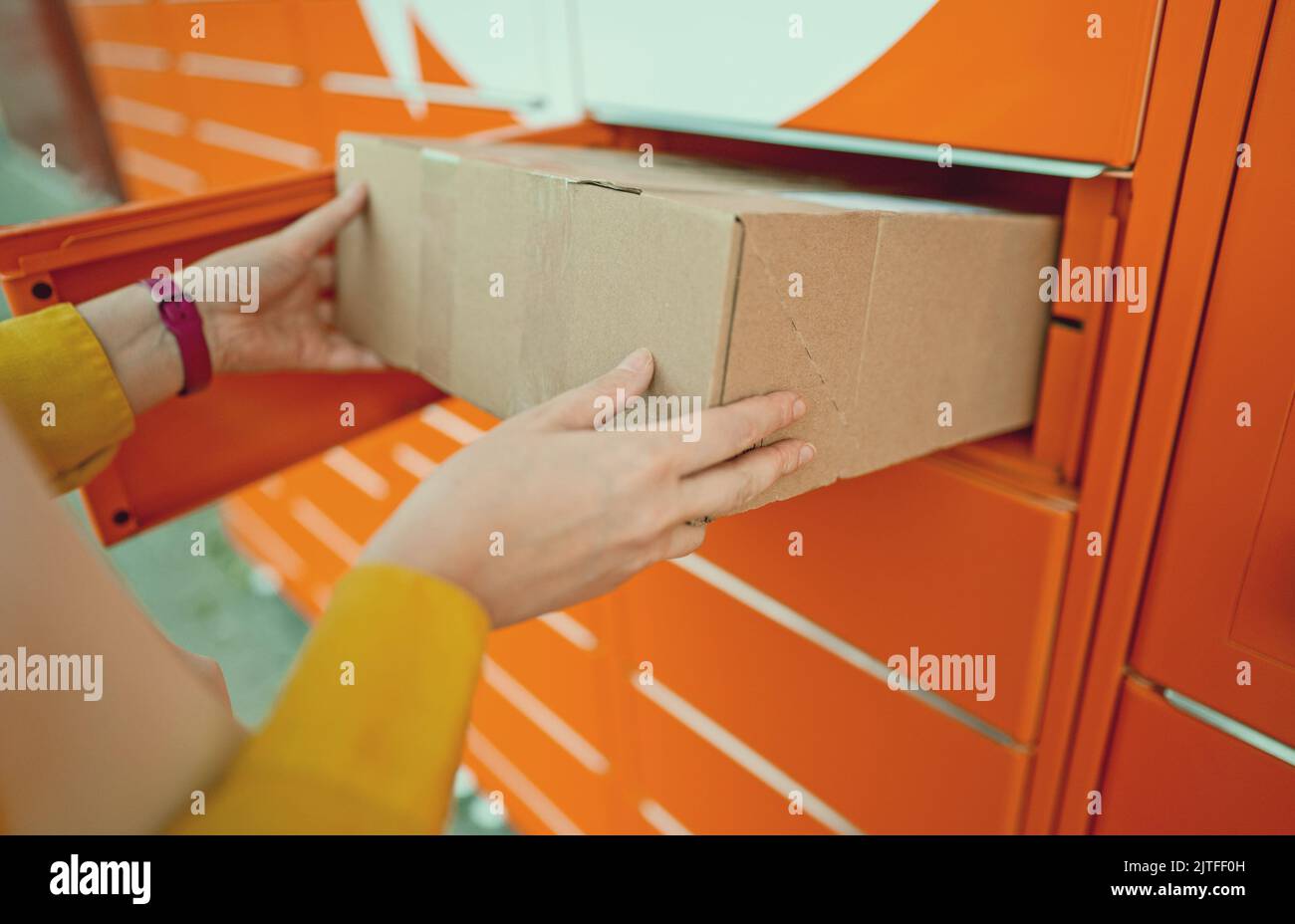 Woman sending mail via automated self-service post terminal machine ... Woman sending mail via automated self-service post terminal machine ...