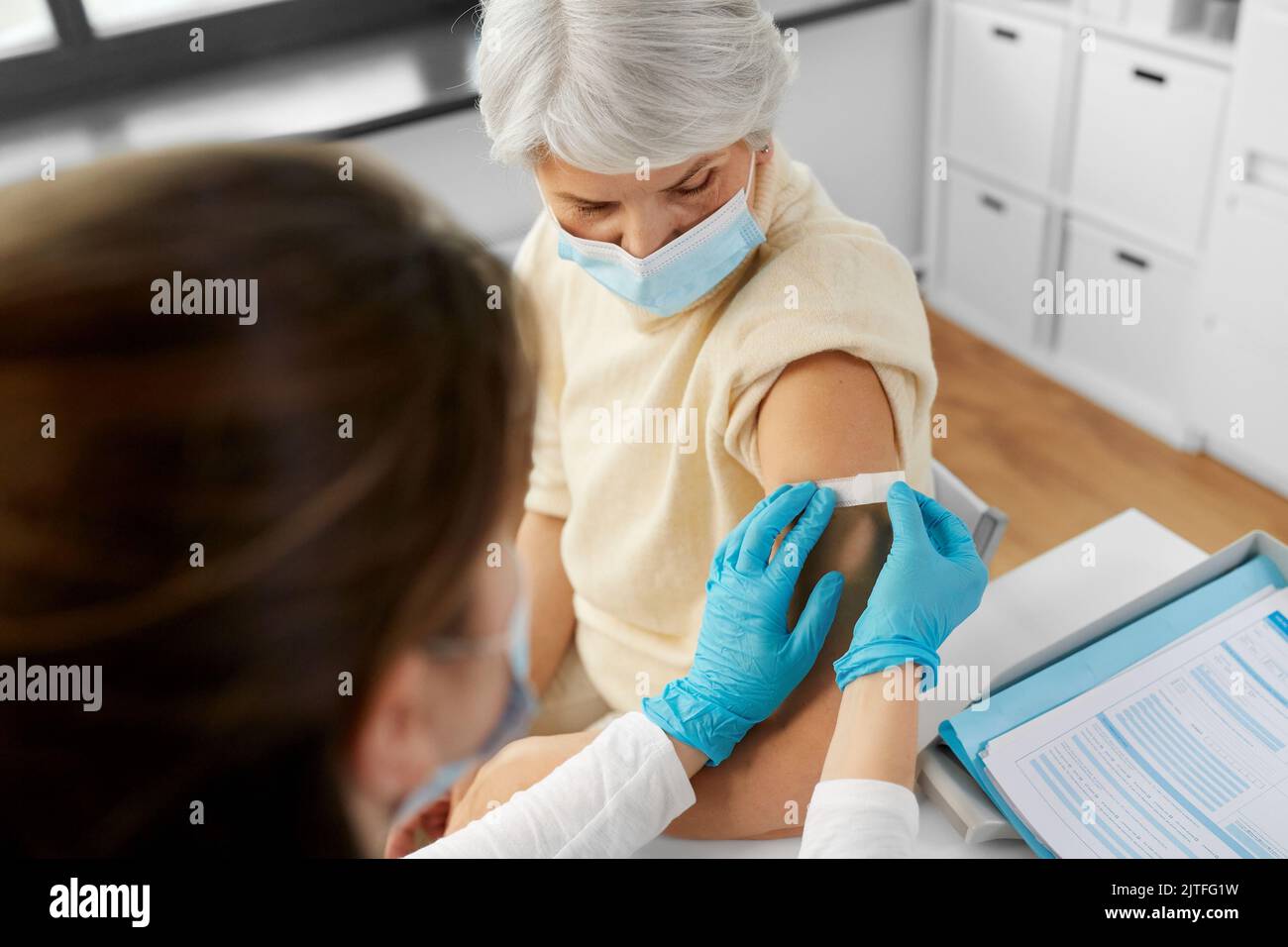 nurse applying medical patch to vaccinated woman Stock Photo - Alamy