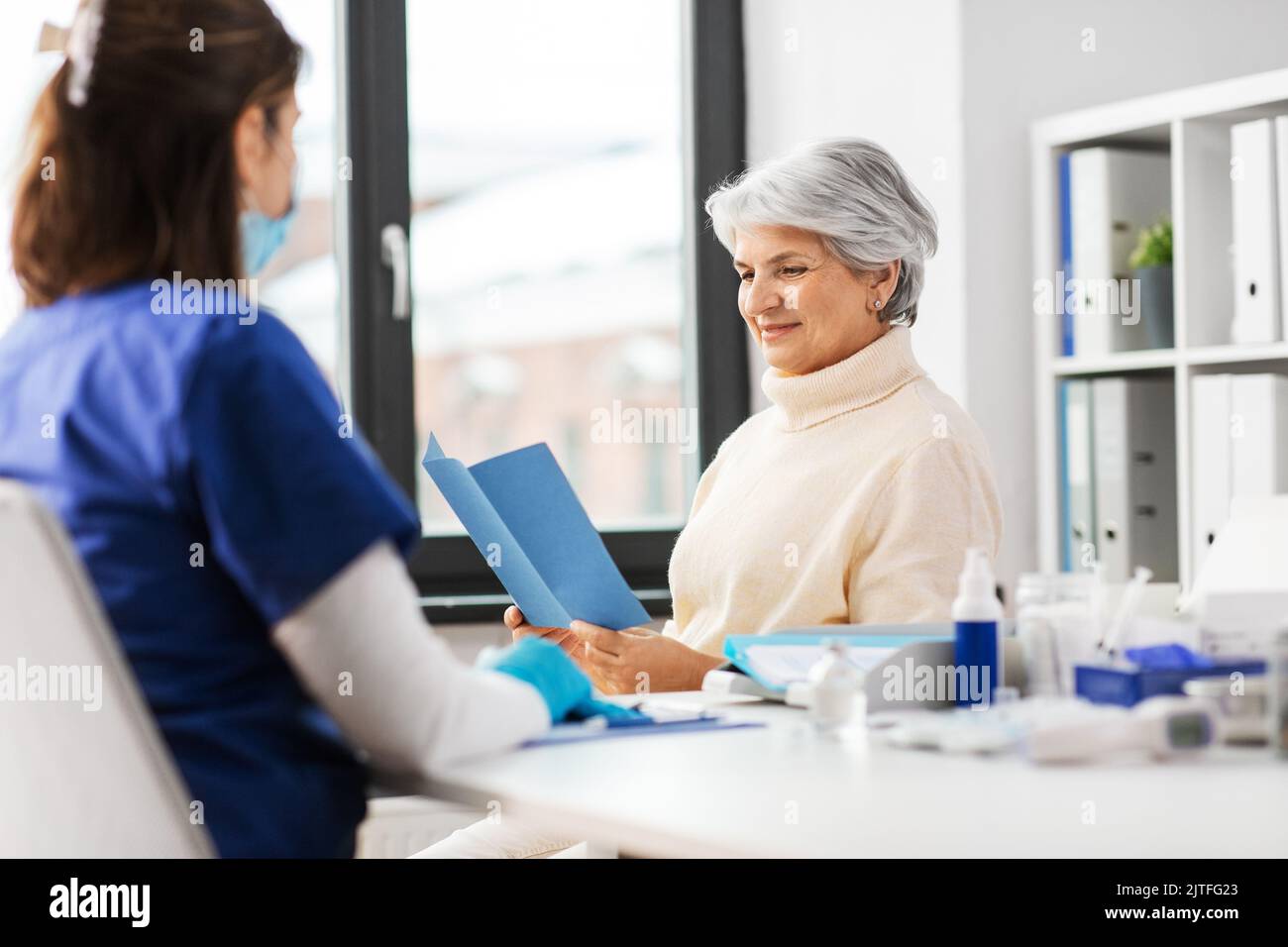 doctor and senior woman reading medical brochure Stock Photo - Alamy