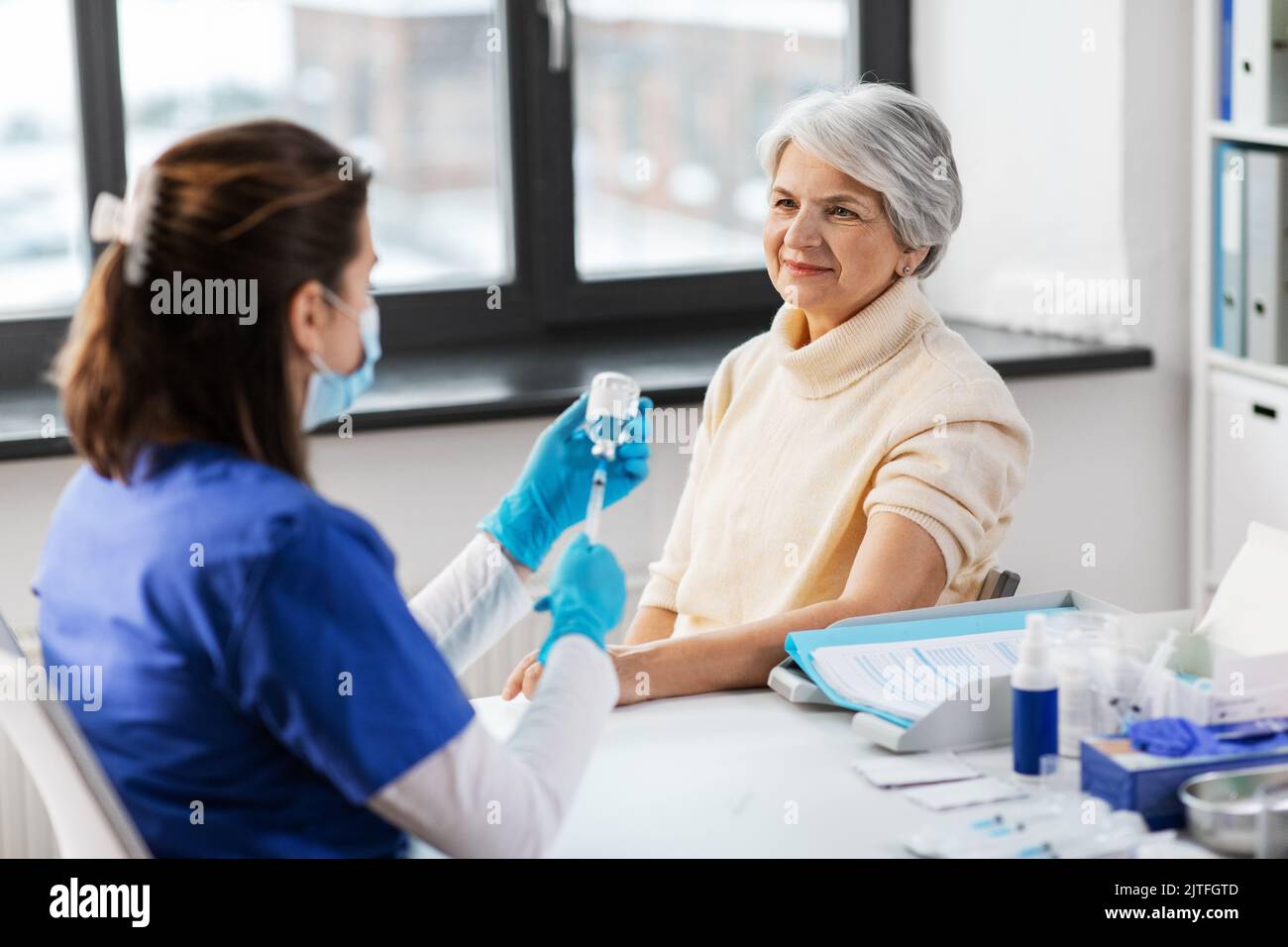 doctor with syringe and senior woman at hospital Stock Photo - Alamy