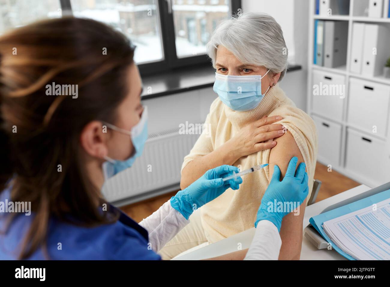 nurse with syringe making injection to woman Stock Photo - Alamy