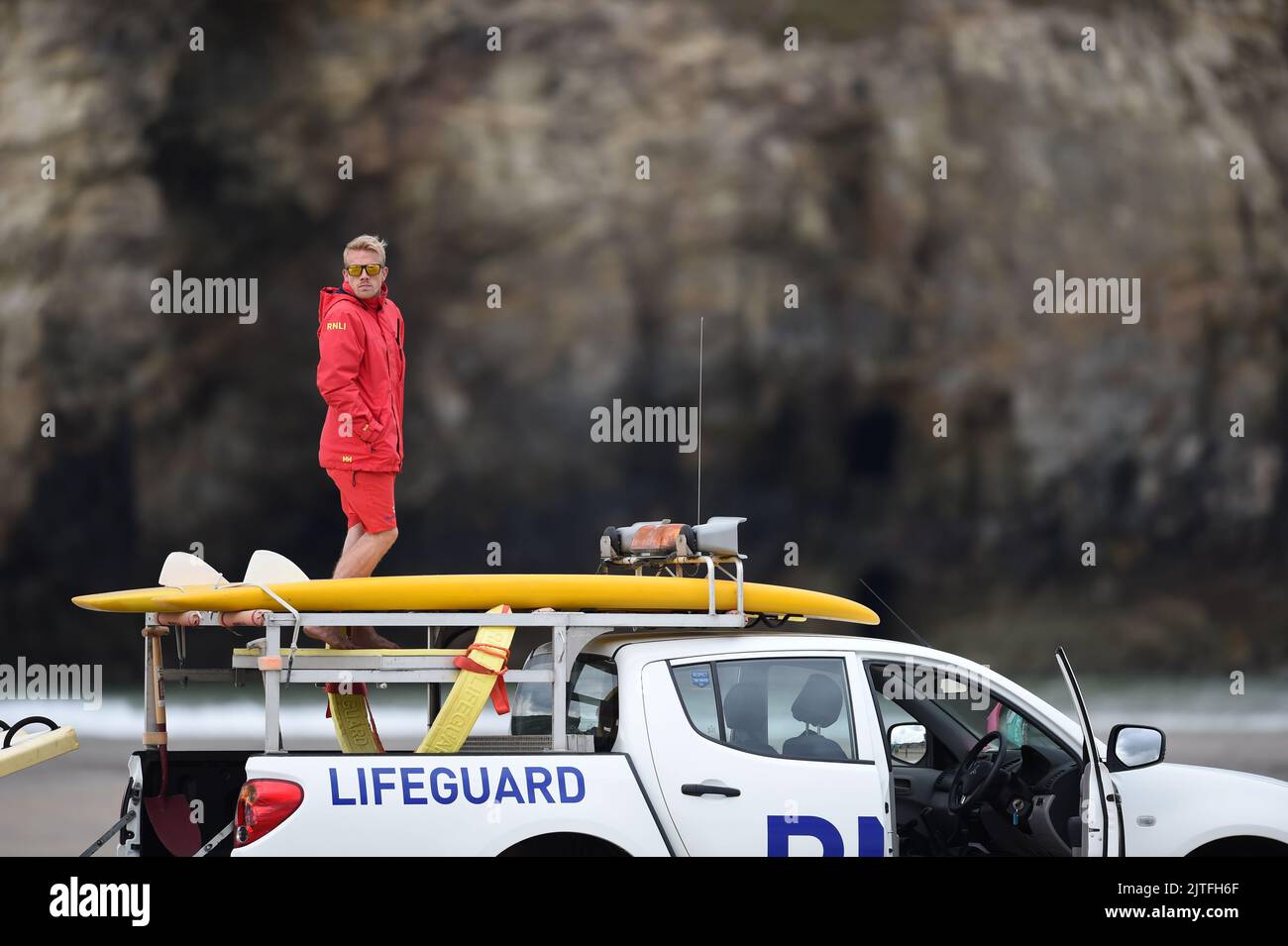 RNLI lifeguard on beach monitoring surfing competition Stock Photo - Alamy