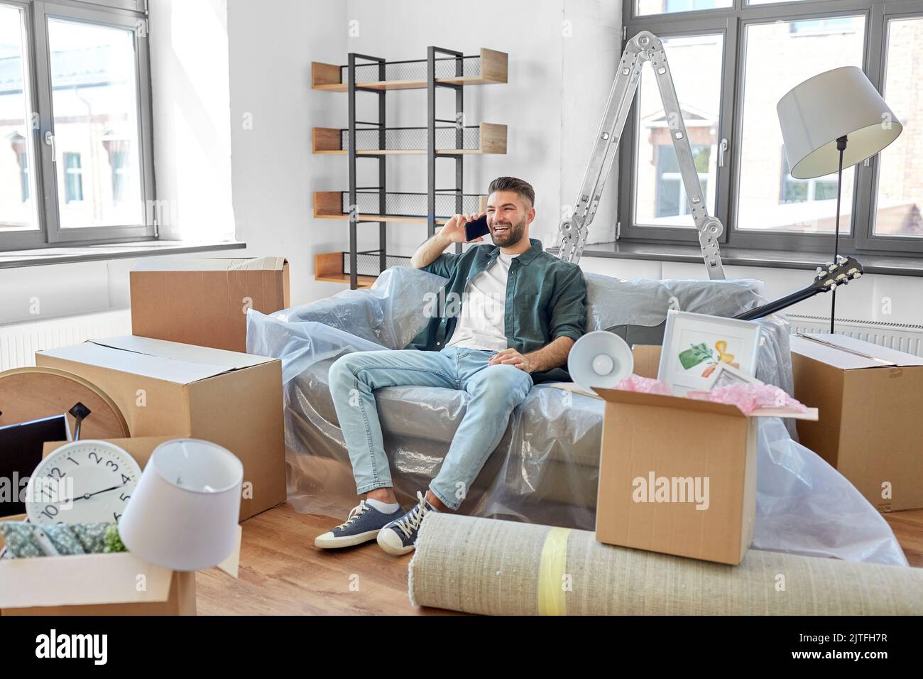happy man calling on smartphone moving to new home Stock Photo - Alamy