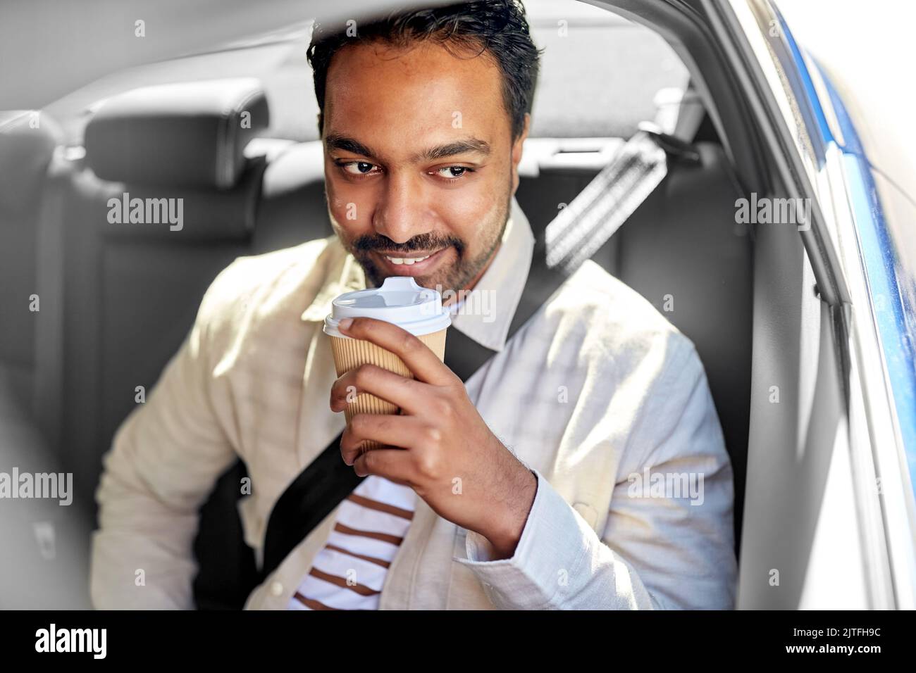 indian man with takeaway coffee on car back seat Stock Photo - Alamy