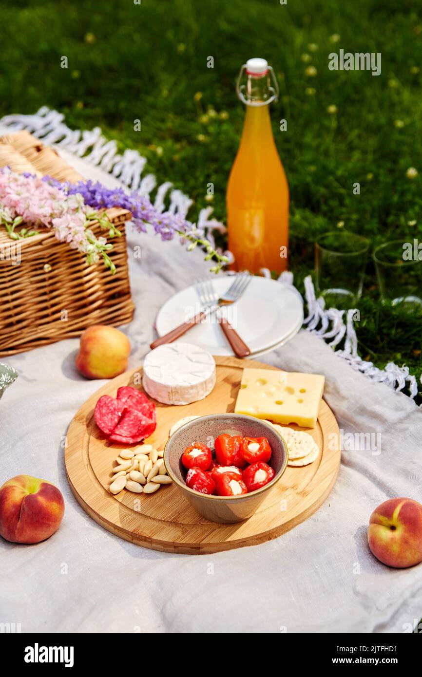 food, drinks and basket on picnic blanket on grass Stock Photo - Alamy