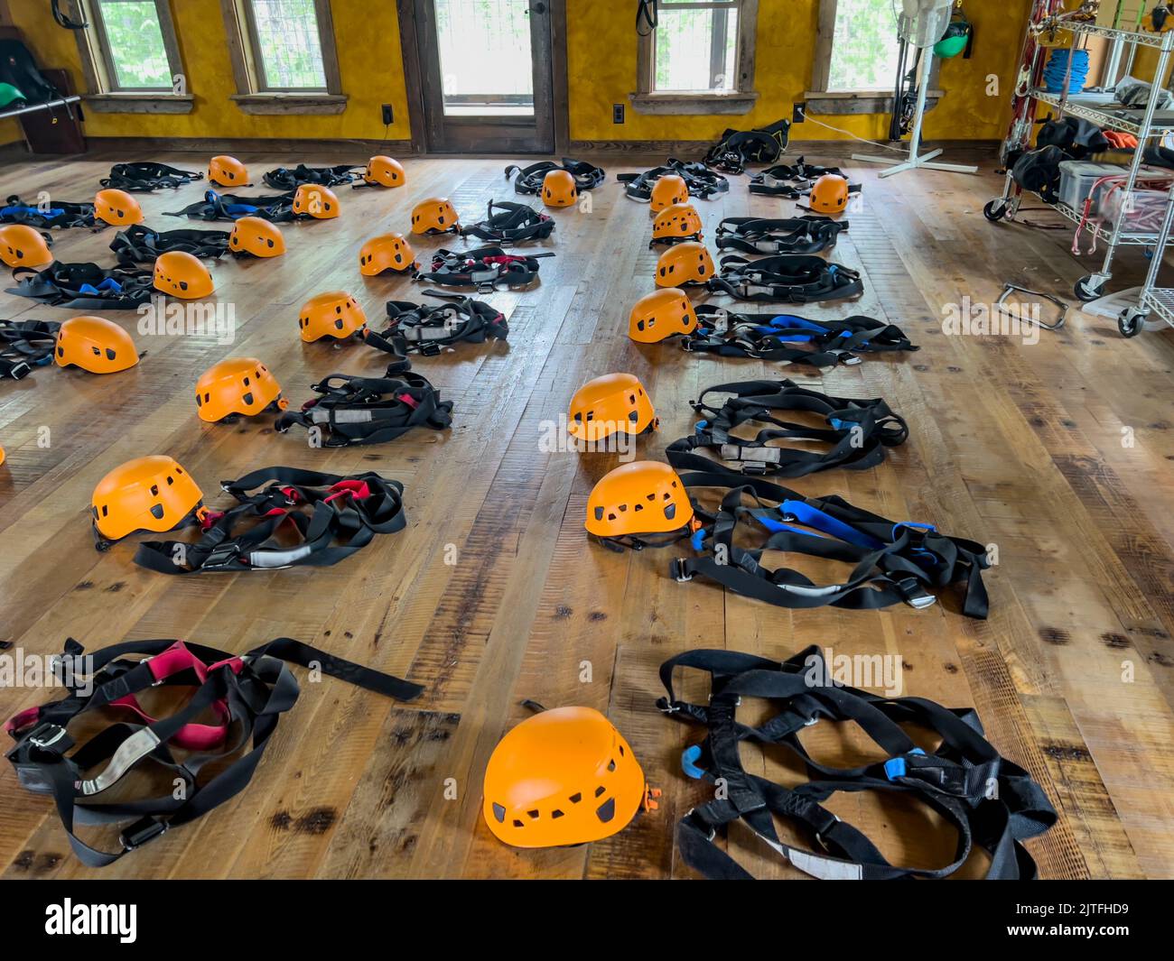 Row of helmets and harnesses ready for use at a high ropes and climbing ...