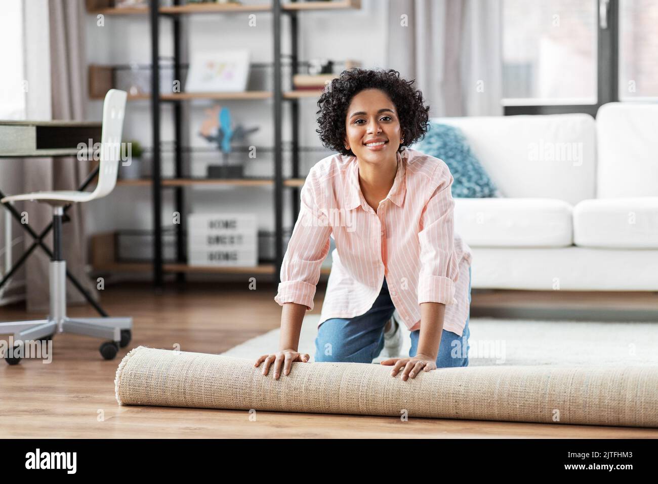 Young woman unfolding carpet hi-res stock photography and images - Alamy