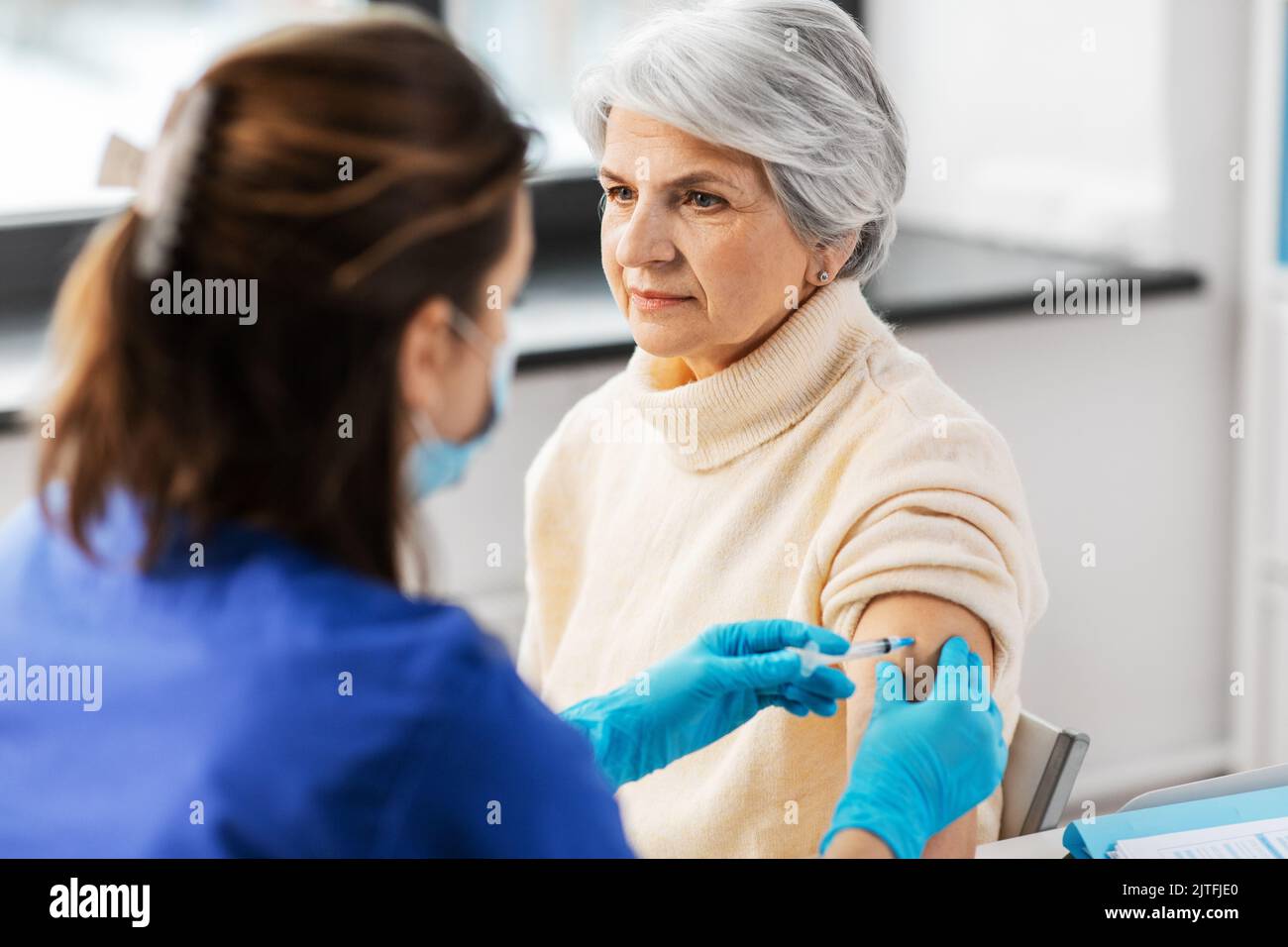 nurse with syringe making injection to woman Stock Photo - Alamy