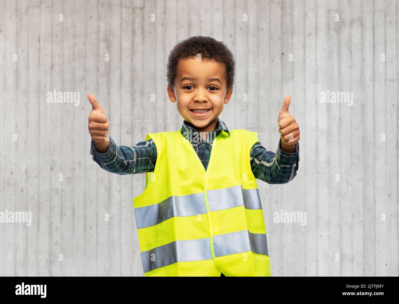 happy little boy in safety vest showing thumbs up Stock Photo - Alamy