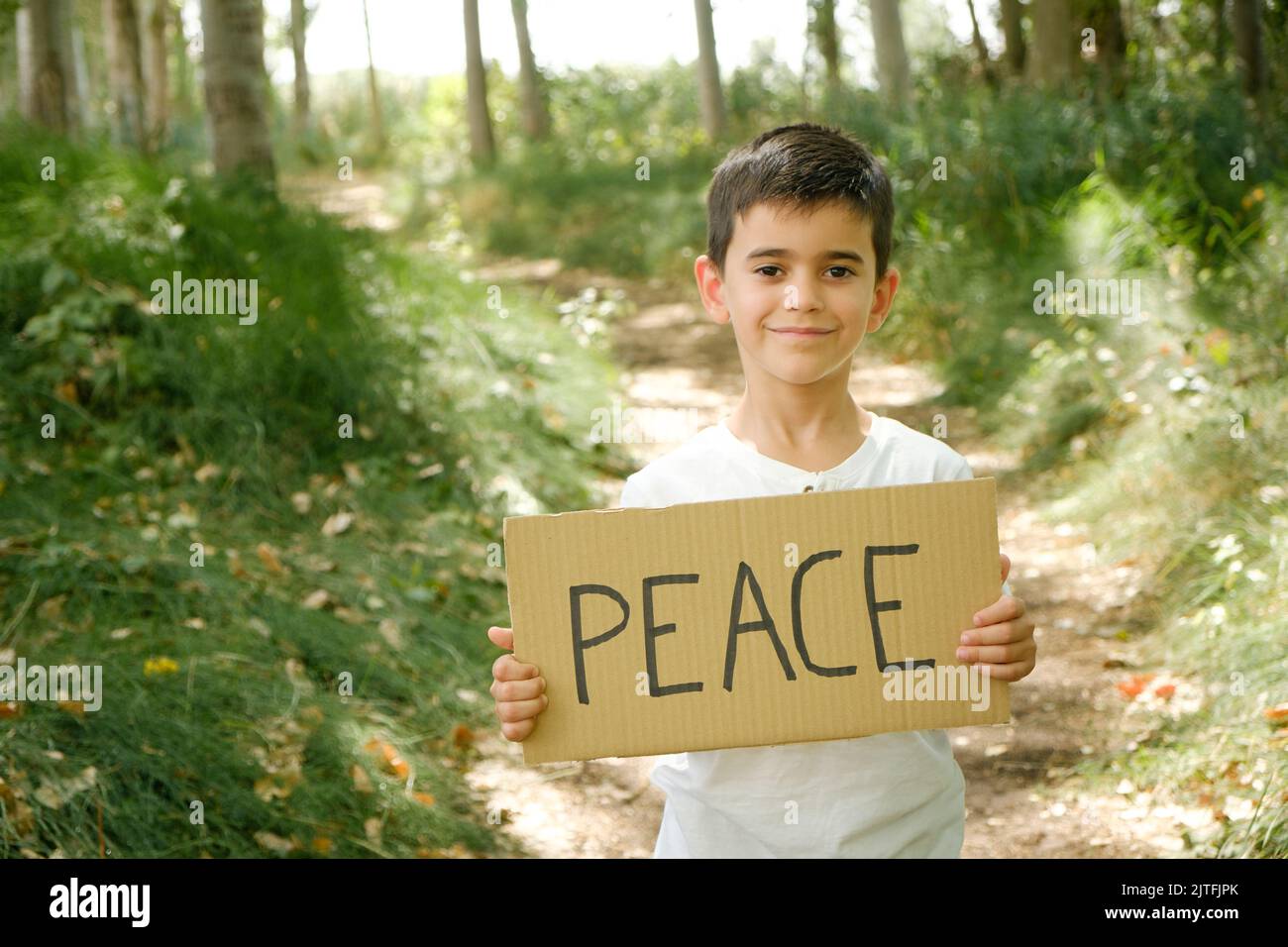 child displays poster with message "peace" in nature Stock Photo - Alamy