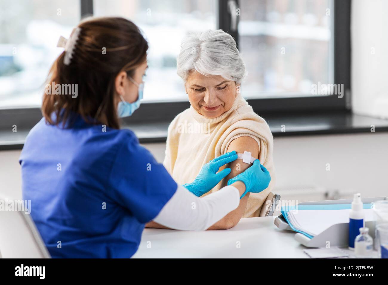 nurse applying medical patch to vaccinated woman Stock Photo - Alamy