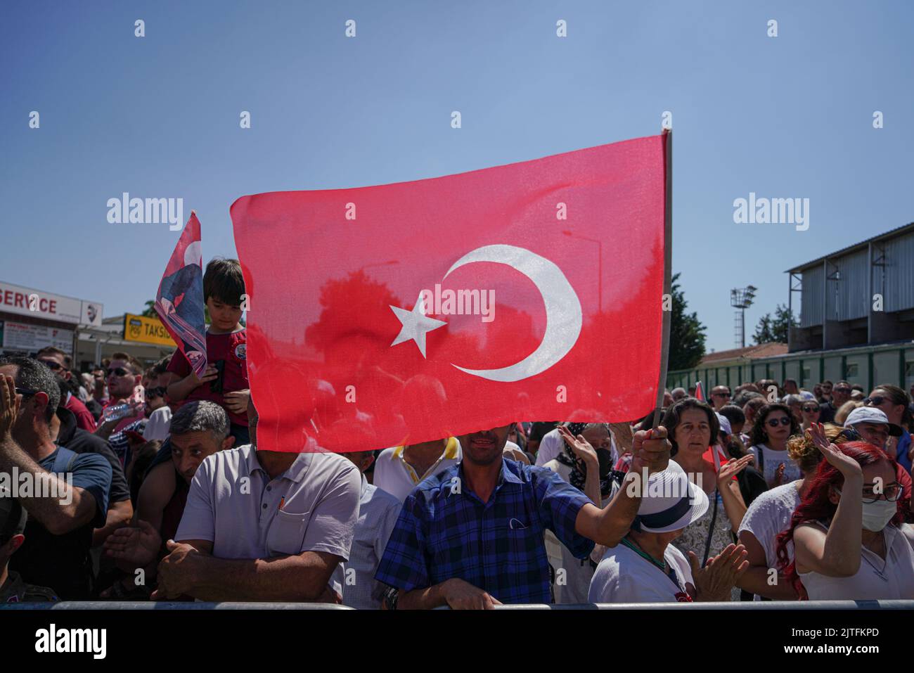 People hold the Turkish flags as they wait in front of the mausoleum ...