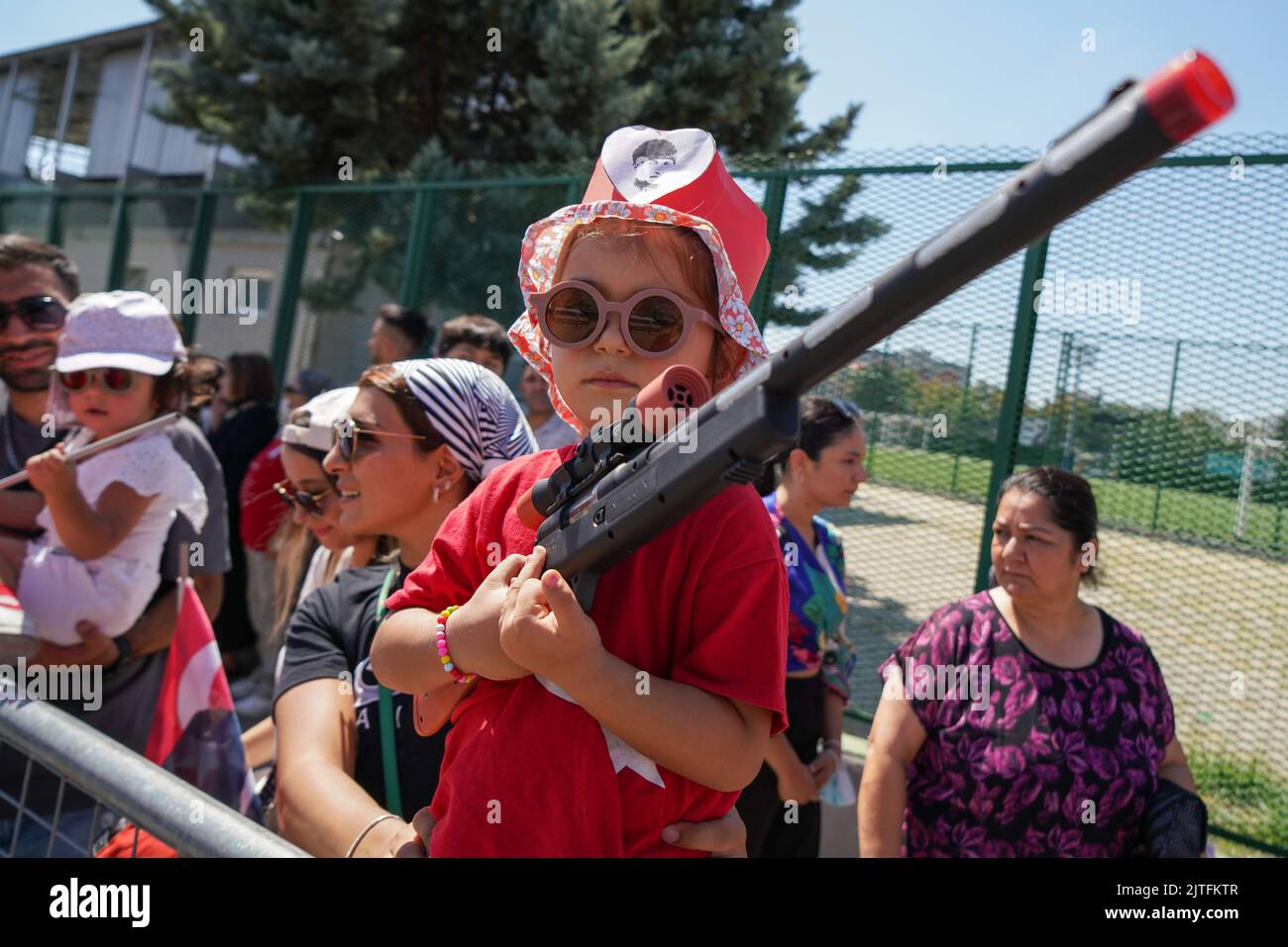A young girl is seen carrying a toy gun in front of the mausoleum, with ...