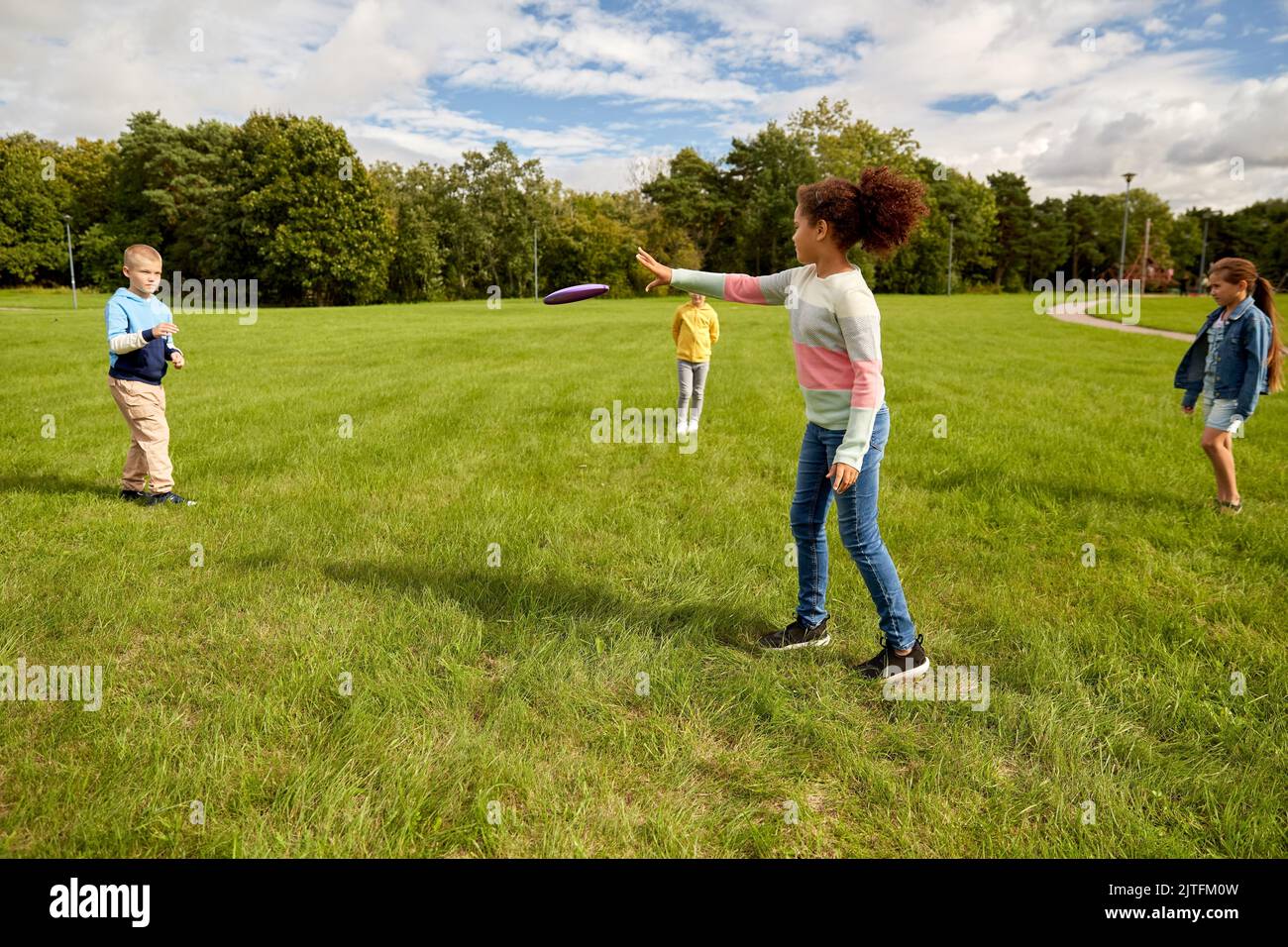 happy children playing with flying disc at park Stock Photo - Alamy